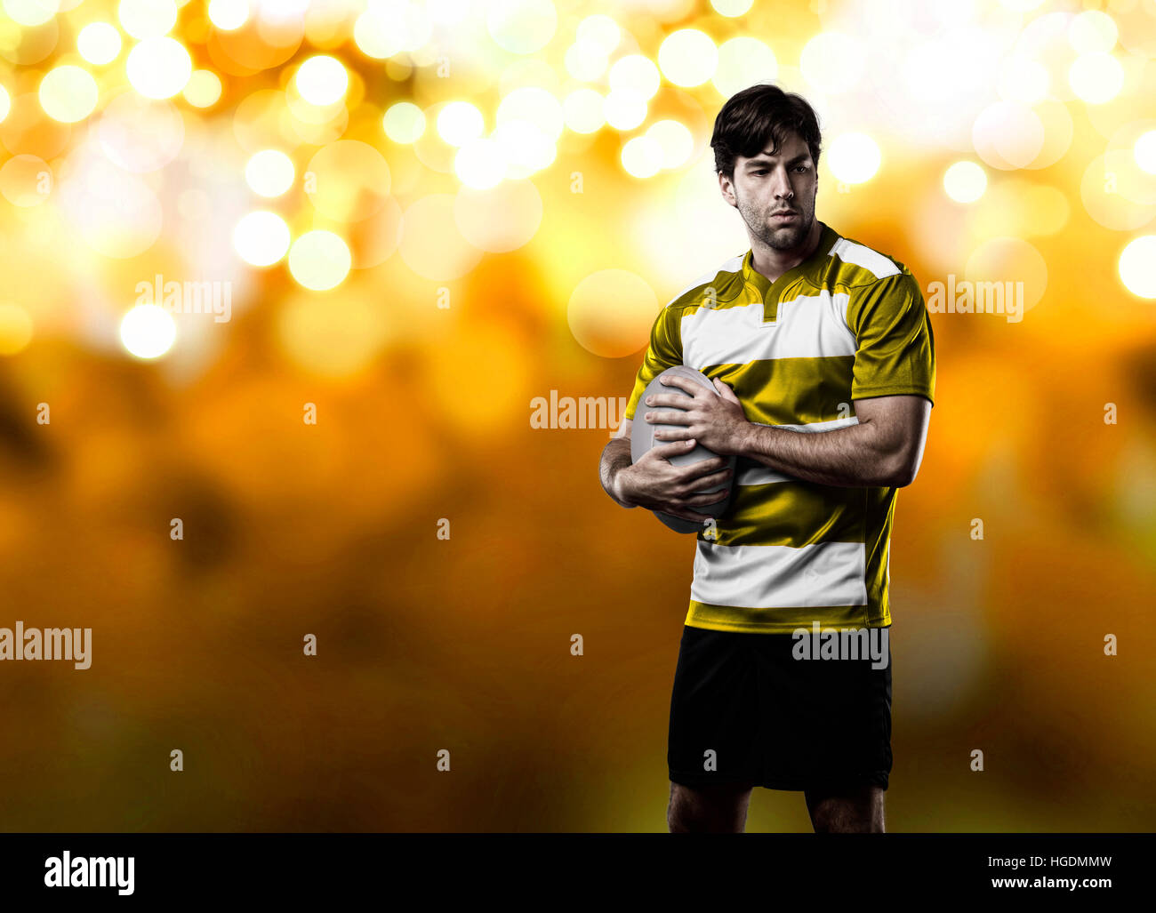 Rugby player in a yellow uniform on a yellow lights background Stock ...