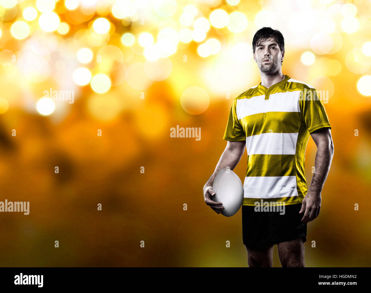 Rugby player in a yellow uniform on a yellow lights background Stock ...