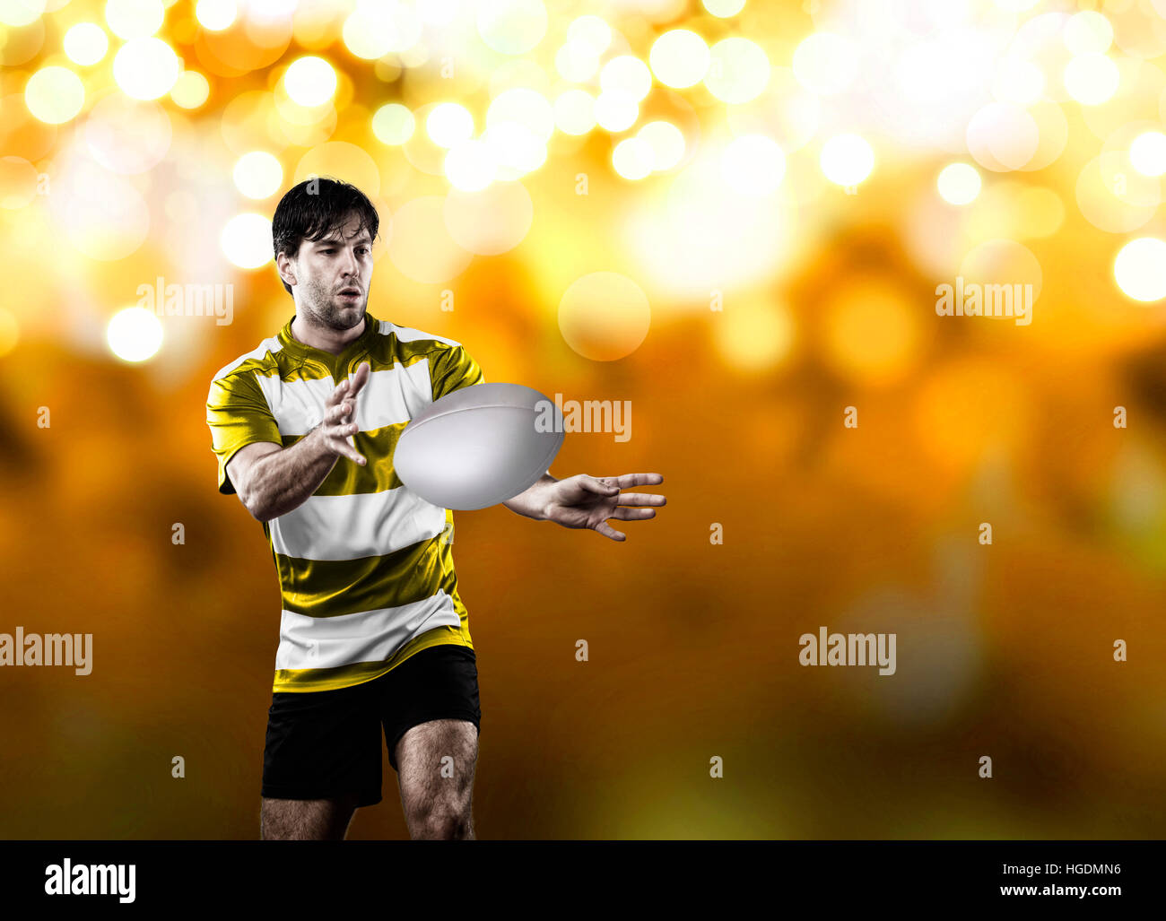 Rugby player in a yellow uniform on a yellow lights background Stock ...