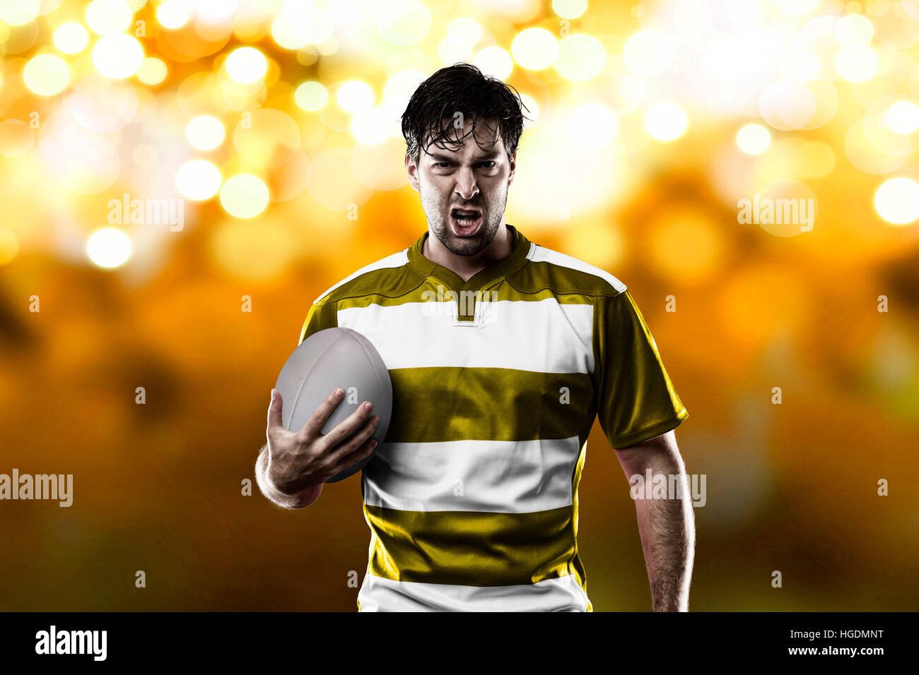 Rugby player in a yellow uniform on a yellow lights background Stock ...