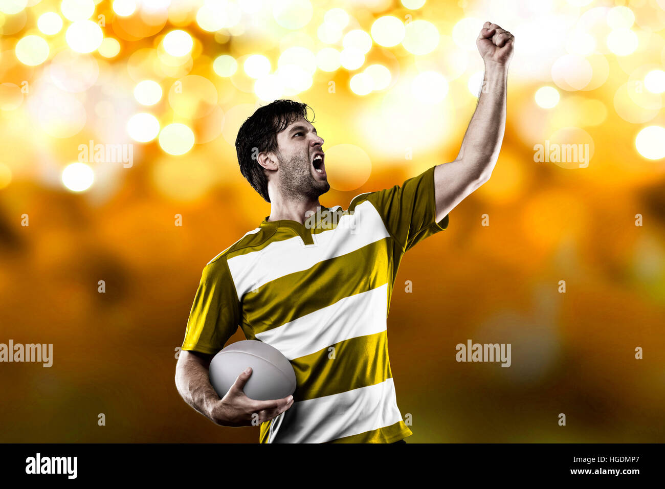 Rugby player in a yellow uniform celebrating on a yellow lights ...