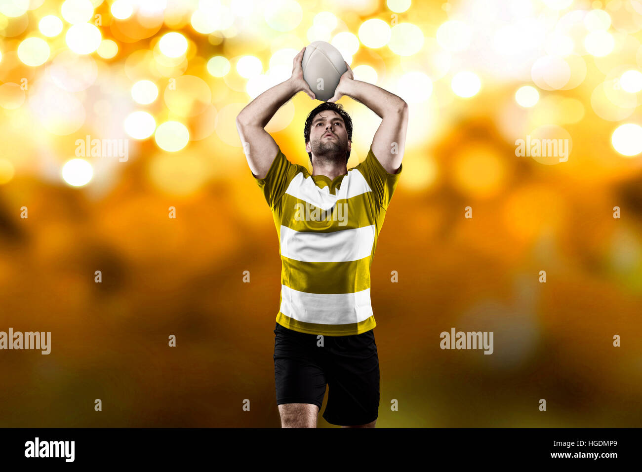 Rugby player in a yellow uniform on a yellow lights background Stock ...