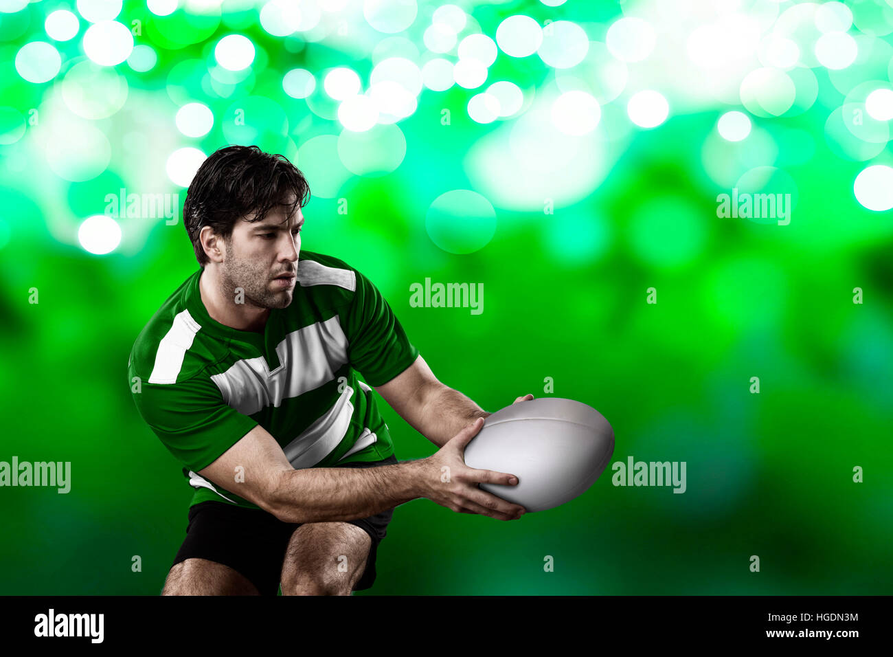 Rugby player in a green uniform on a green lights backgrond Stock Photo ...