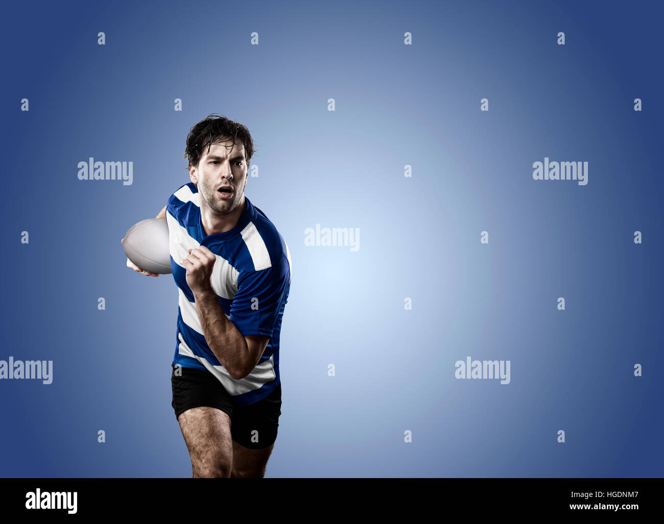 Rugby player in a blue uniform running on a blue background Stock Photo ...