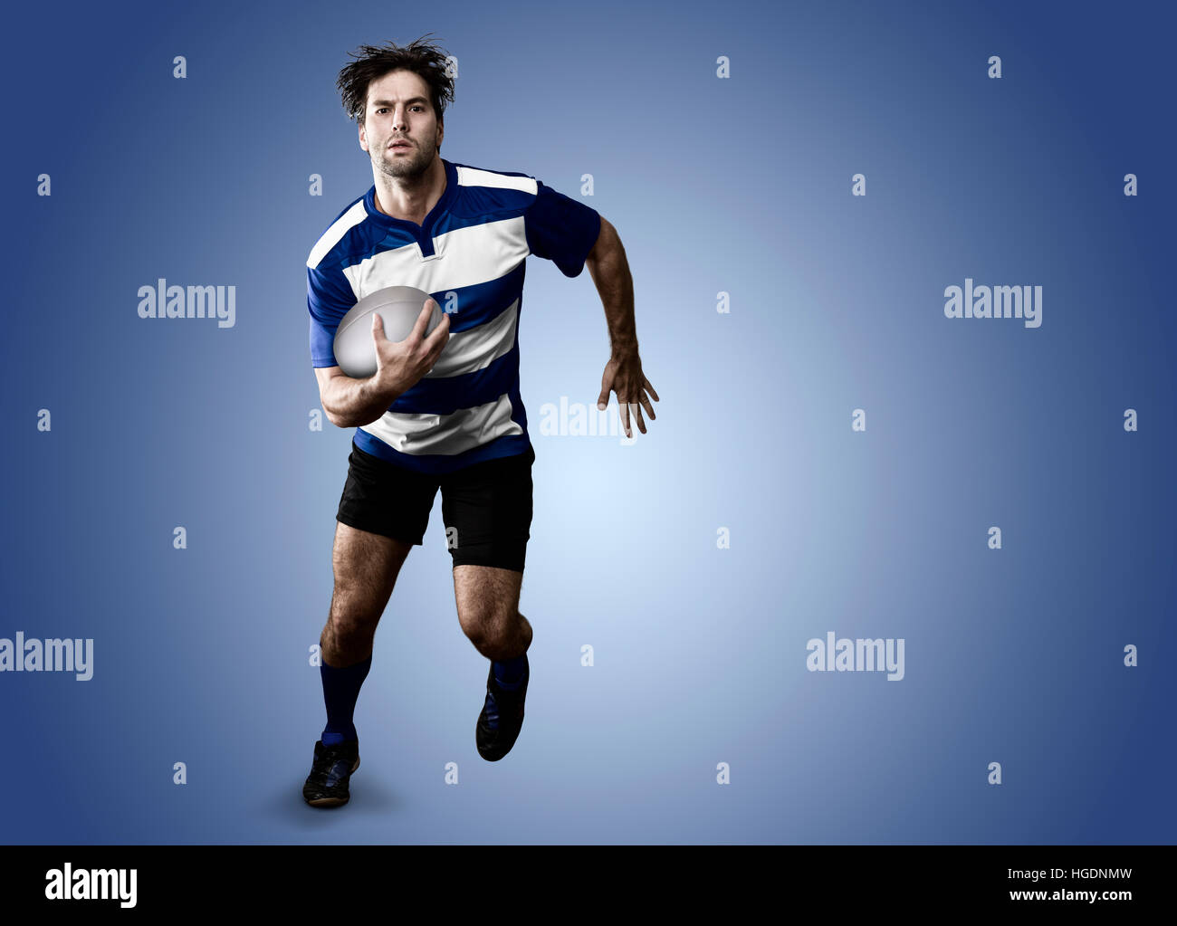 Rugby player in a blue uniform running on a blue background Stock Photo ...