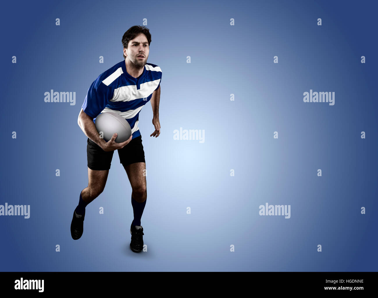 Rugby player in a blue uniform running on a blue background Stock Photo ...