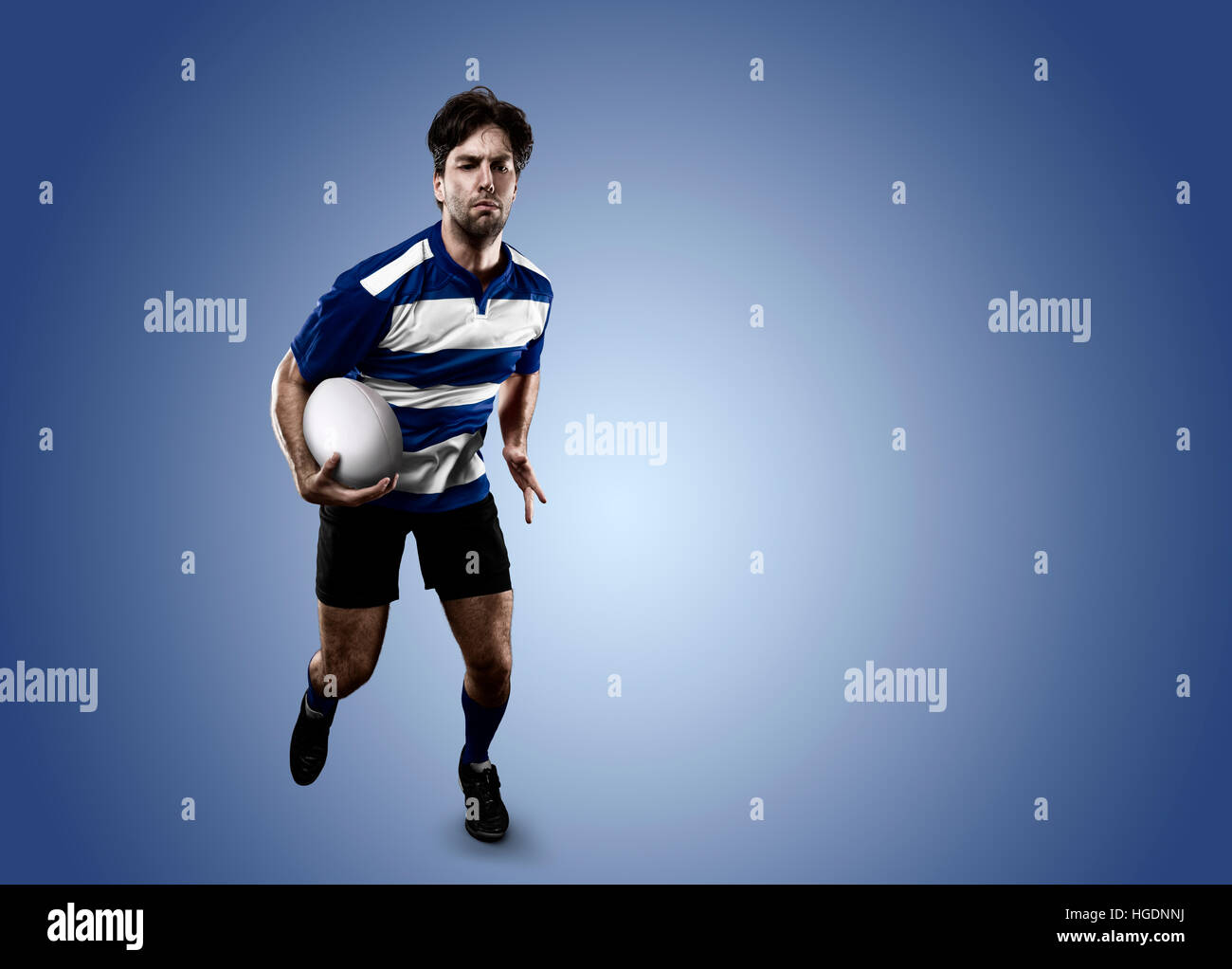 Rugby player in a blue uniform running on a blue background Stock Photo ...