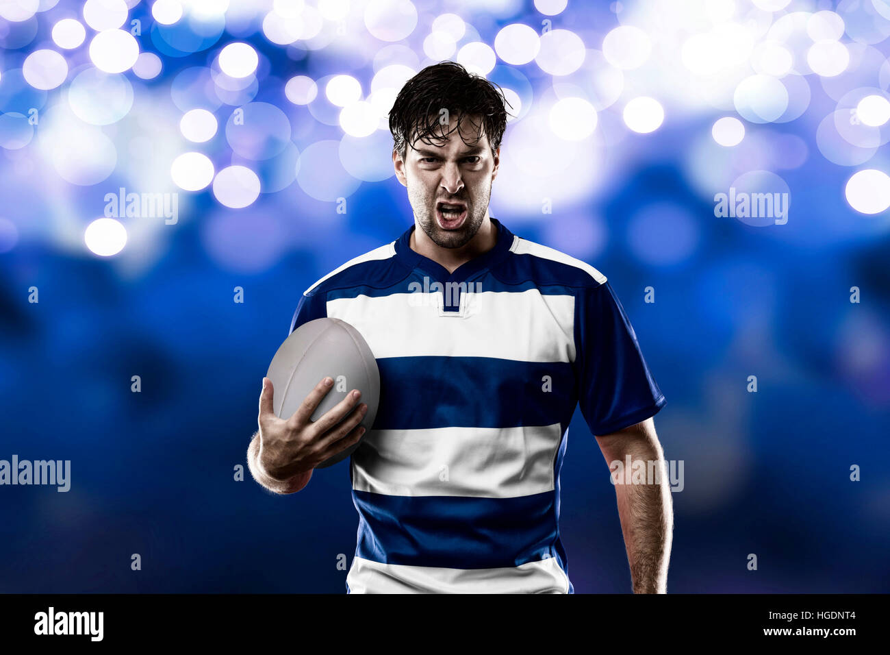 Rugby player in a blue uniform on a blue lights background Stock Photo ...