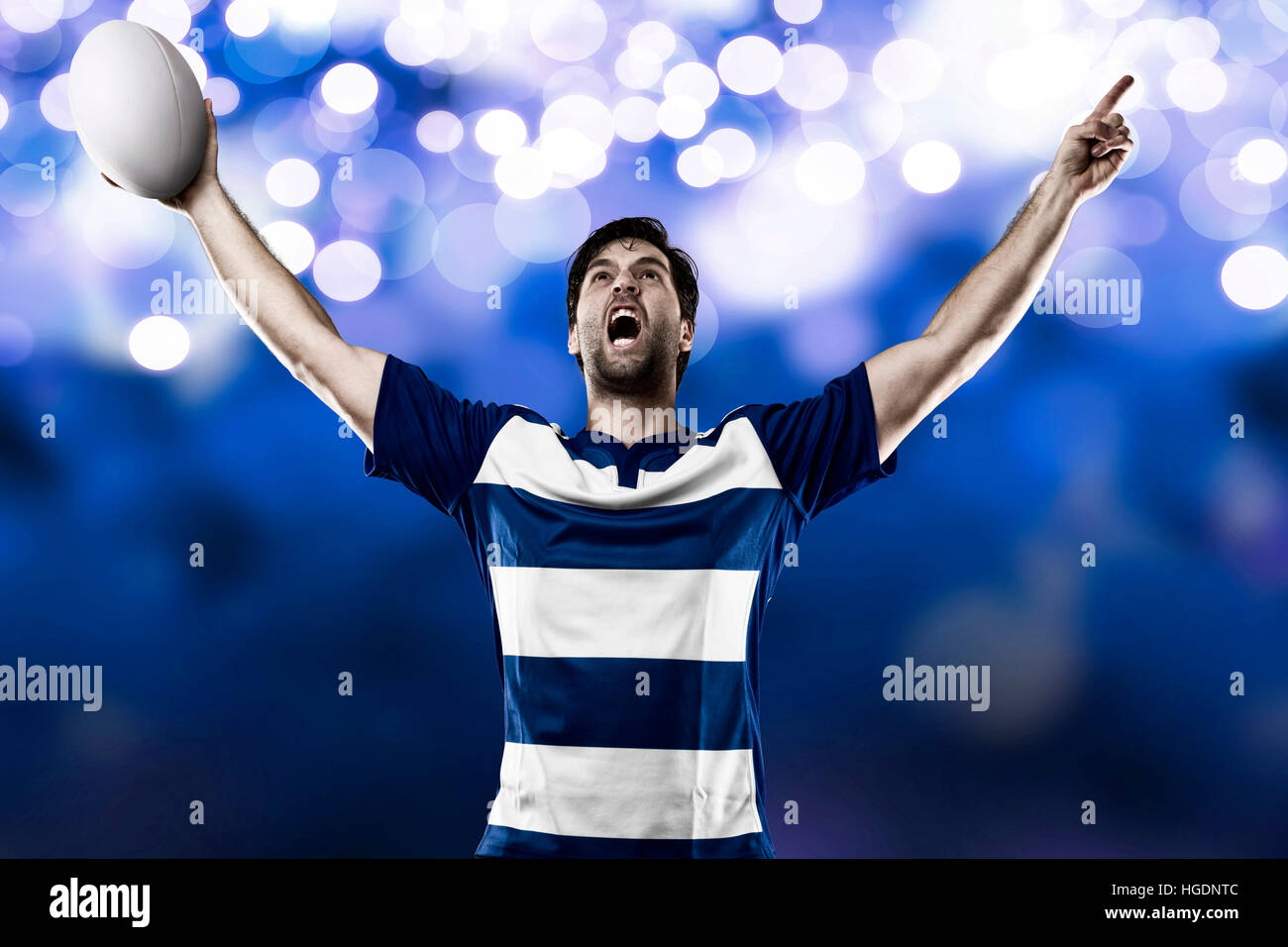 Rugby player in a blue uniform celebrating on a blue lights background ...