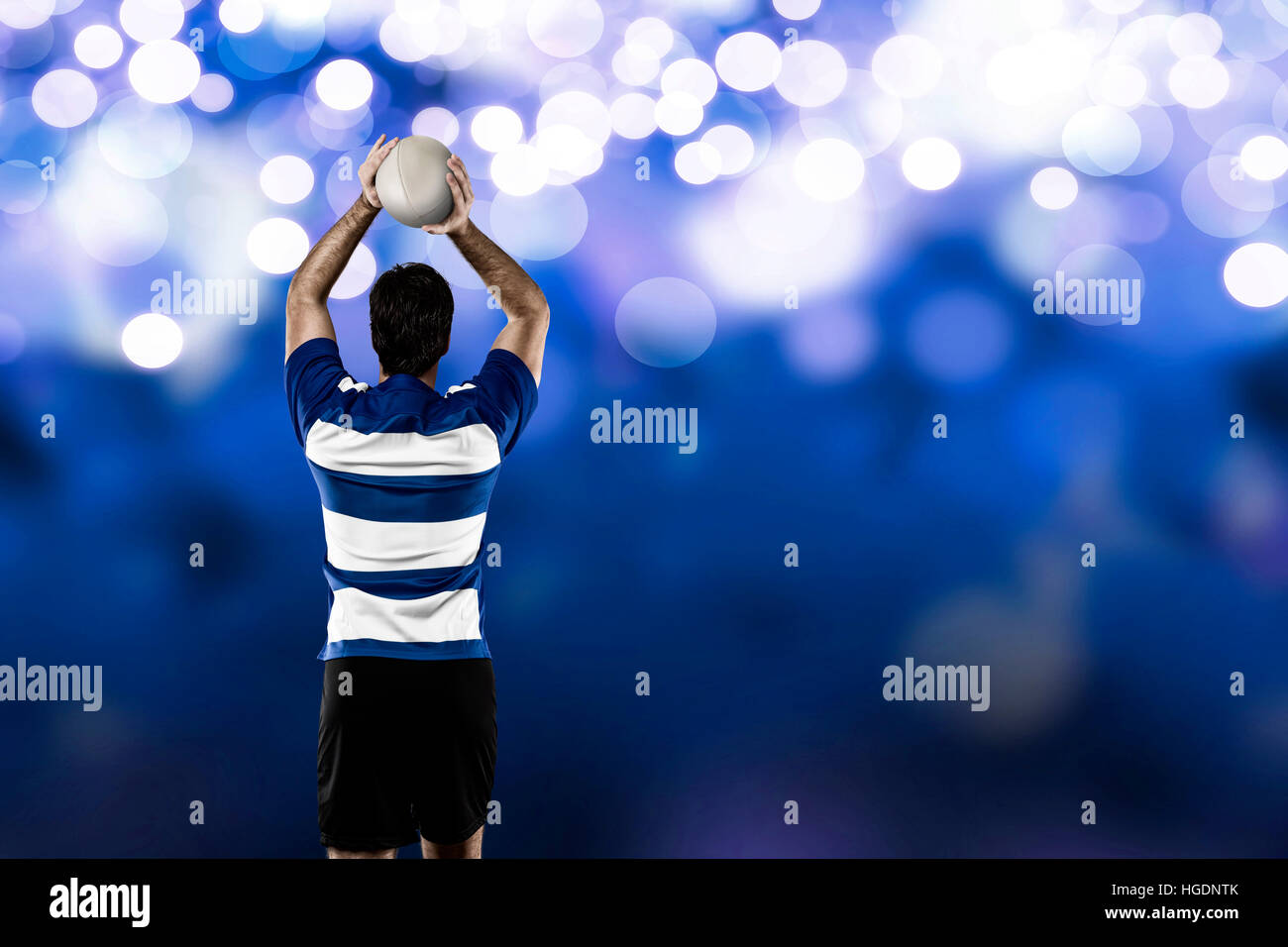 Rugby player in a blue uniform on a blue lights background Stock Photo ...