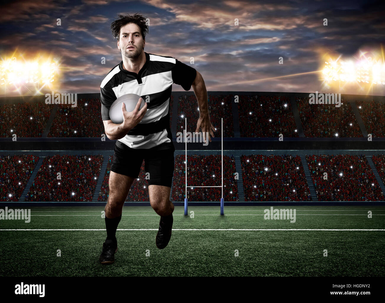 Rugby player in a black uniform running on a stadium Stock Photo - Alamy