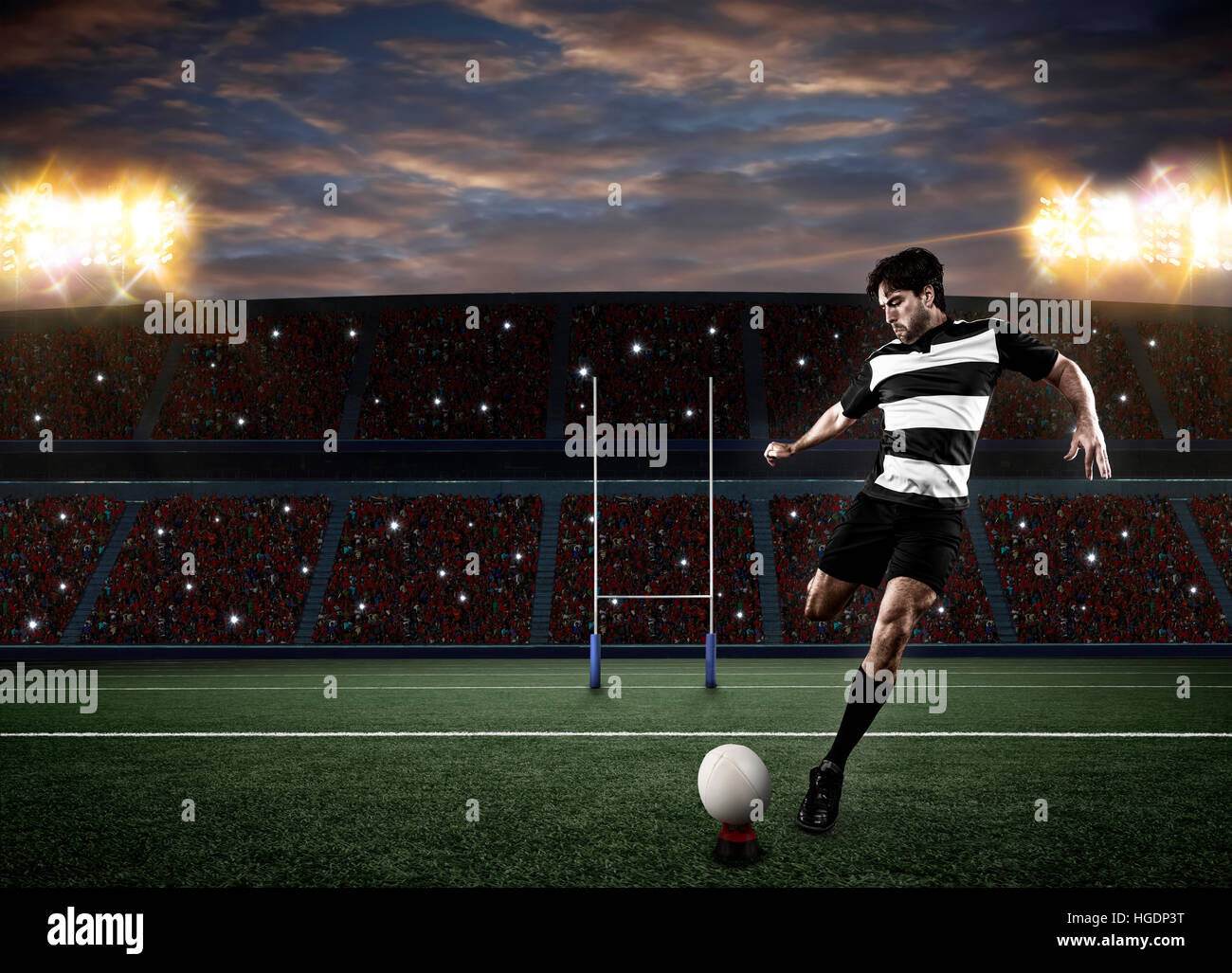 Rugby player in a black uniform kicking a ball on a stadium Stock Photo ...