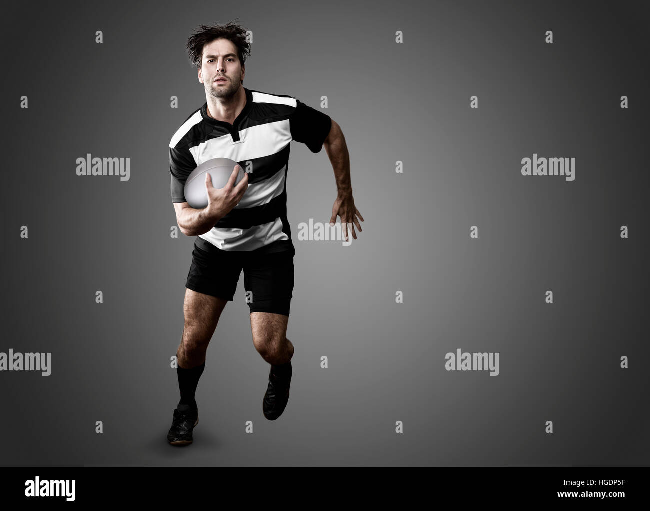 Rugby player in a black uniform running on a black background Stock ...