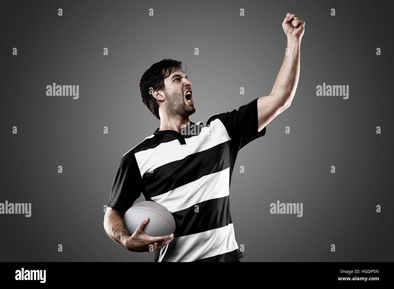 Rugby player in a black uniform celebrating on a black background Stock ...