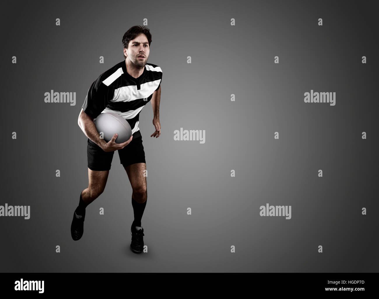 Rugby player in a black uniform running on a black background Stock ...