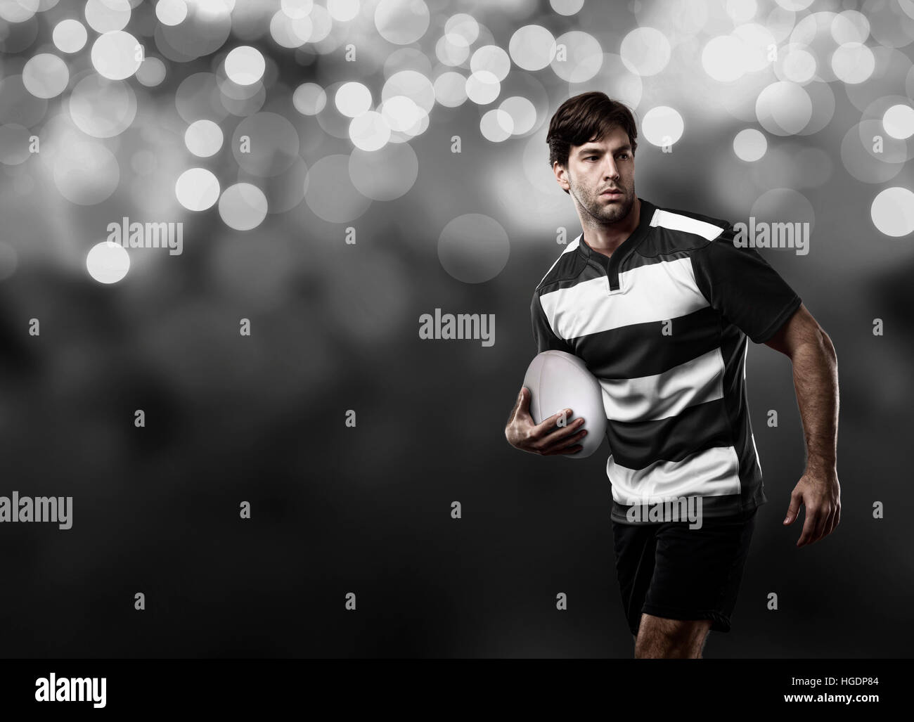 Rugby player in a black uniform on a black lights background Stock ...