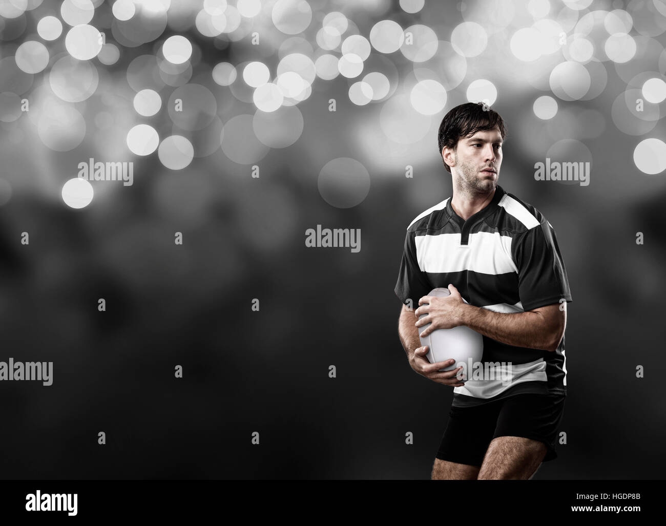 Rugby player in a black uniform on a black lights background Stock ...