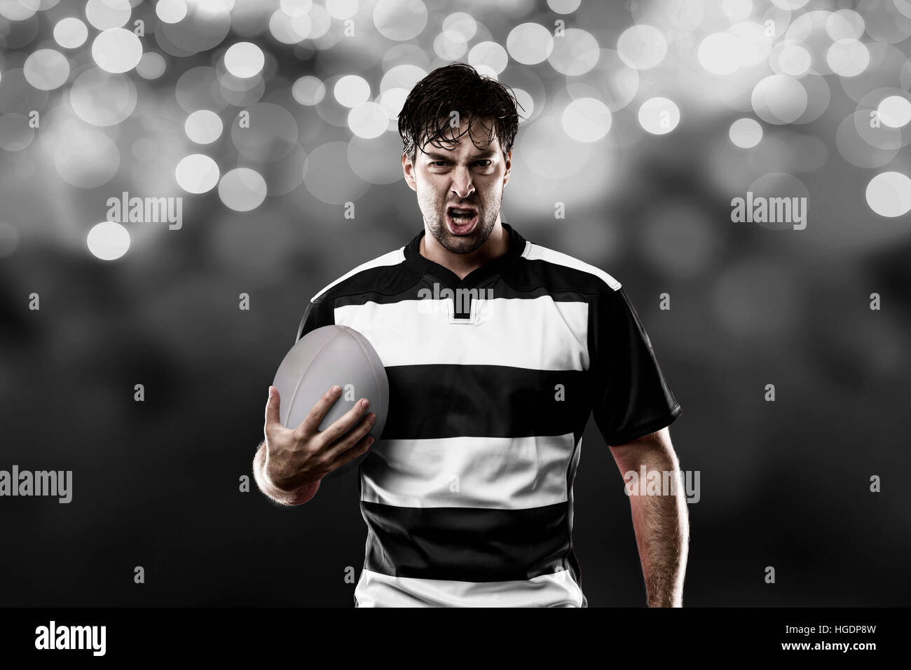 Rugby player in a black uniform on a black lights background Stock ...
