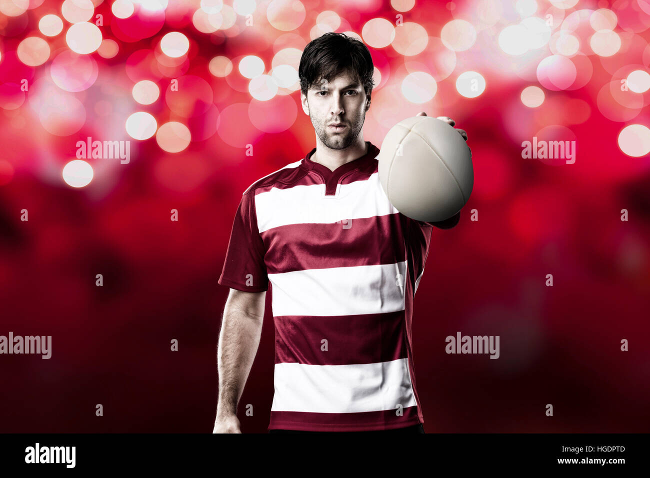 Rugby player in a red uniform on a red lights background Stock Photo ...