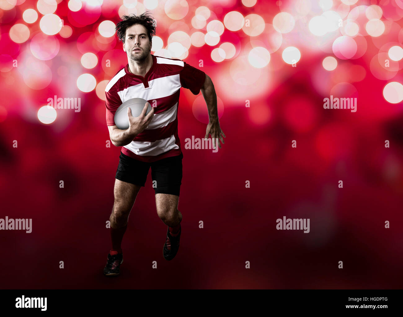 Rugby player in a red uniform running on a red lights background Stock ...