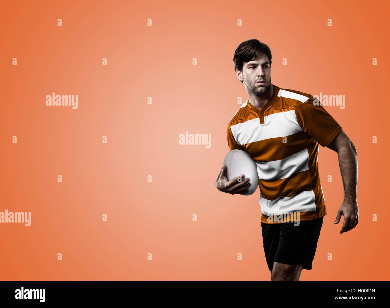 Rugby player in a orange uniform on a orange background Stock Photo - Alamy
