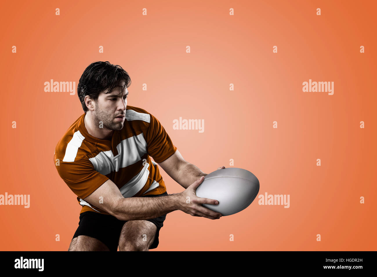Rugby player in a orange uniform on a orange background Stock Photo - Alamy