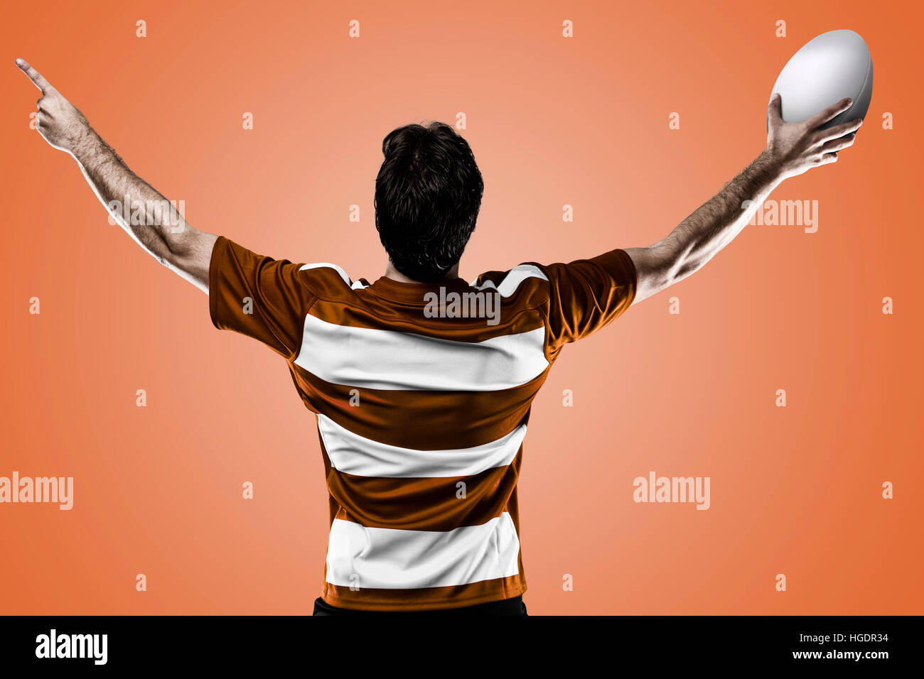 Rugby player in a orange uniform celebrating on a orange background ...