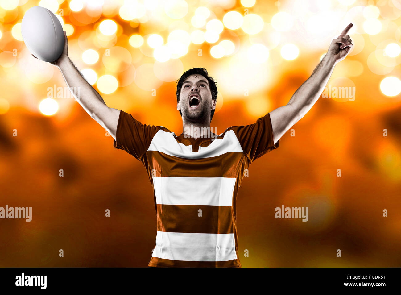 Rugby player in a orange uniform celebrating on a orange lights ...