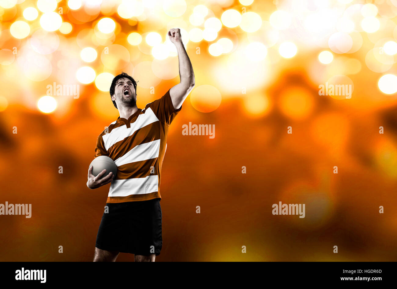Rugby player in a orange uniform celebrating on a orange lights ...