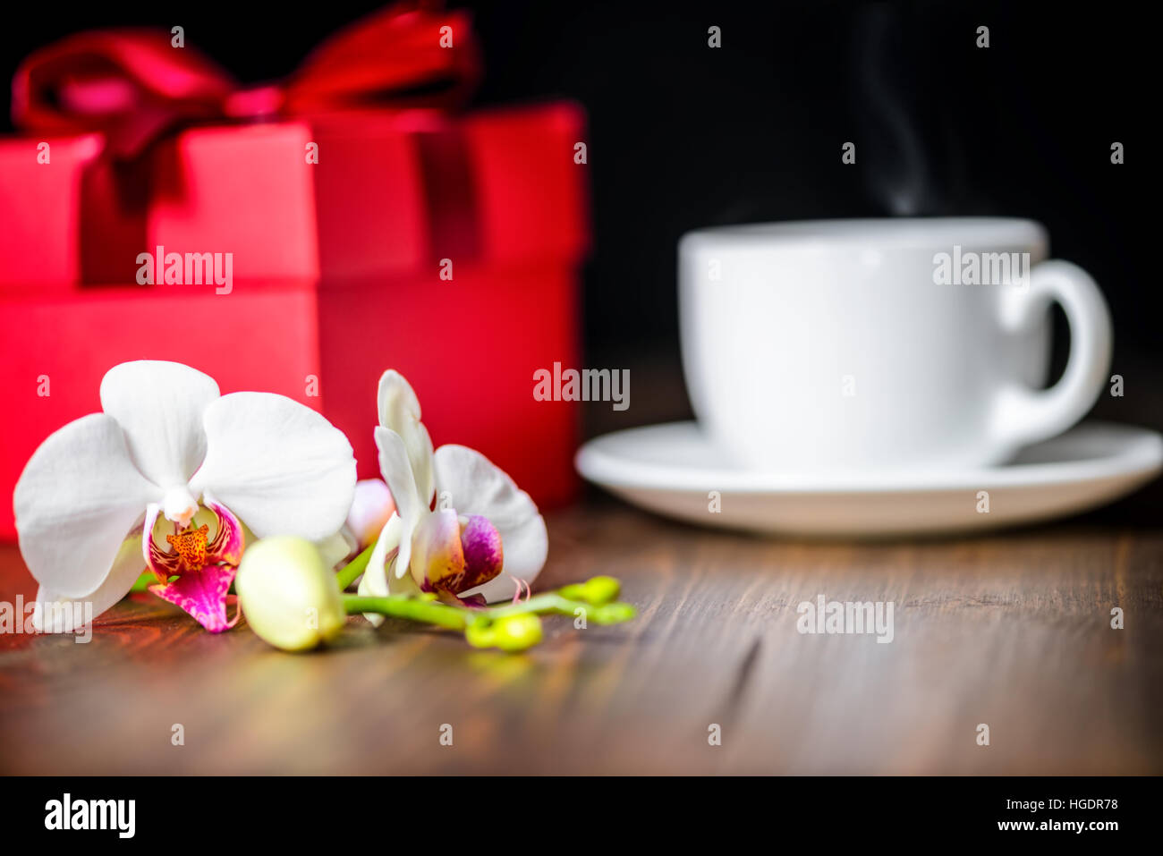 greeting red box with bow, orchid flower, phalaenopsis and cap of tea ...