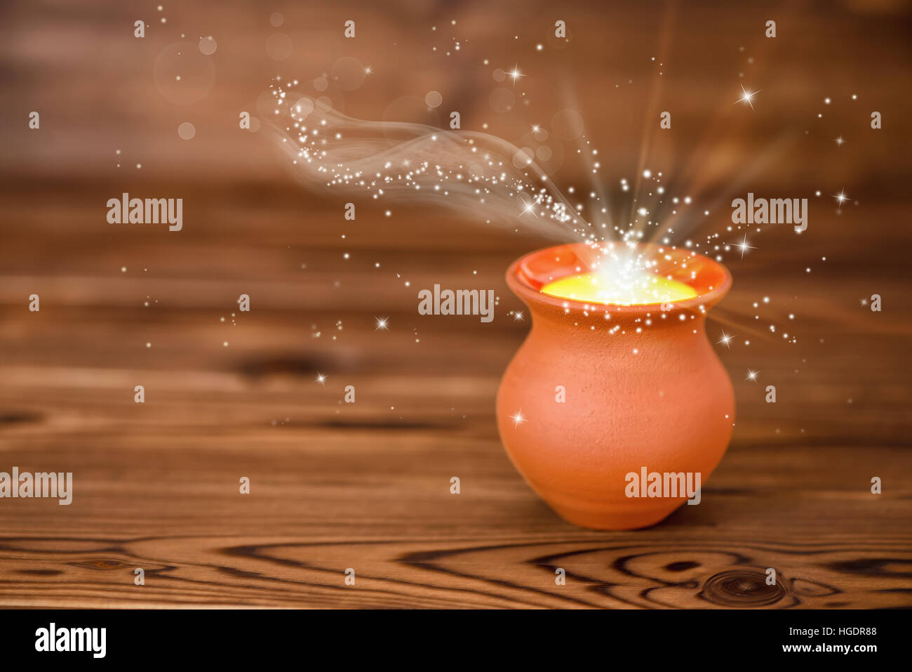 concept greeting card of clay pot with mystical miracle light on wooden ...