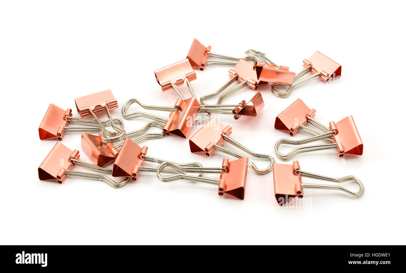 Seventeen copper-coloured metal binder clips, isolated on a white ...