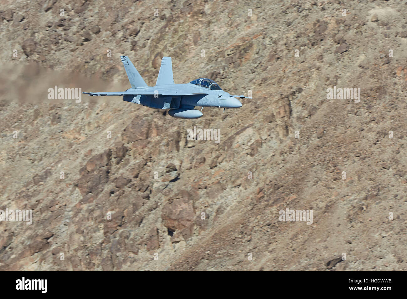 United States Navy F-18-F Flying At Low Level Through A Desert Valley ...