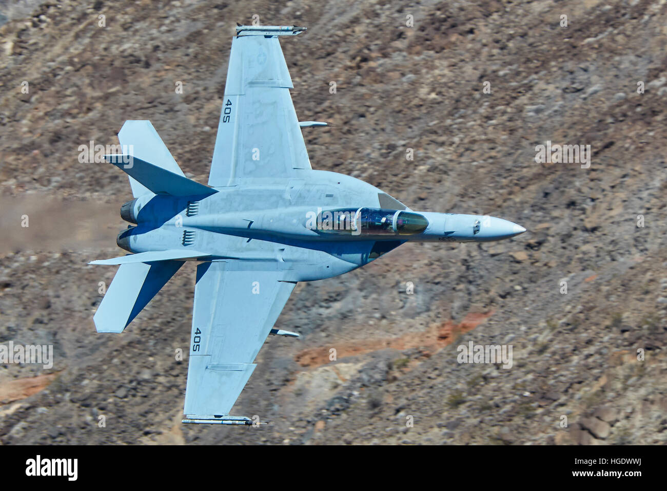 United States Navy F-18-F Flying At Low Level Through A Desert Valley ...