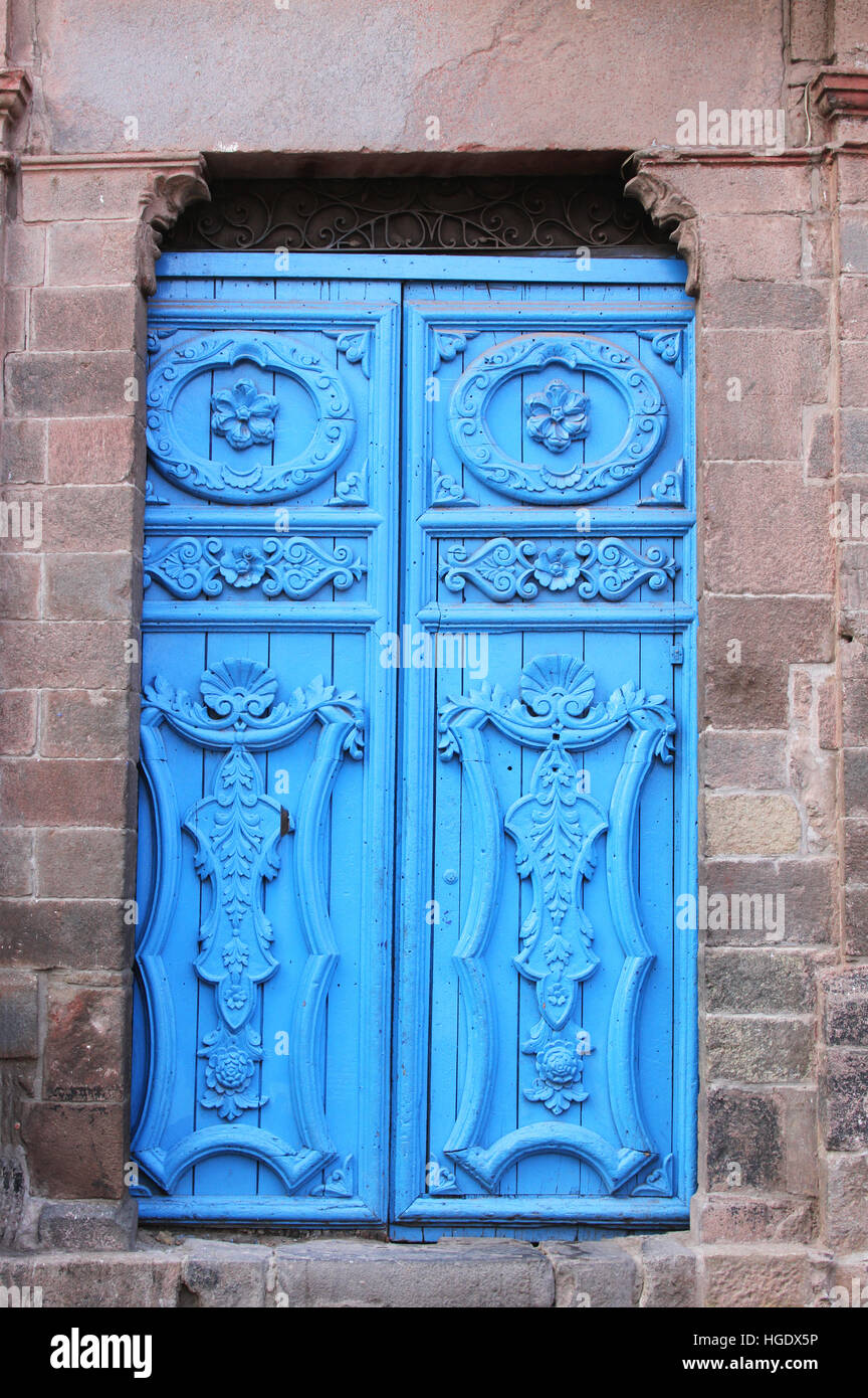 Bright blue carved wooden door set in stone wall in Cuzco, Peru Stock ...