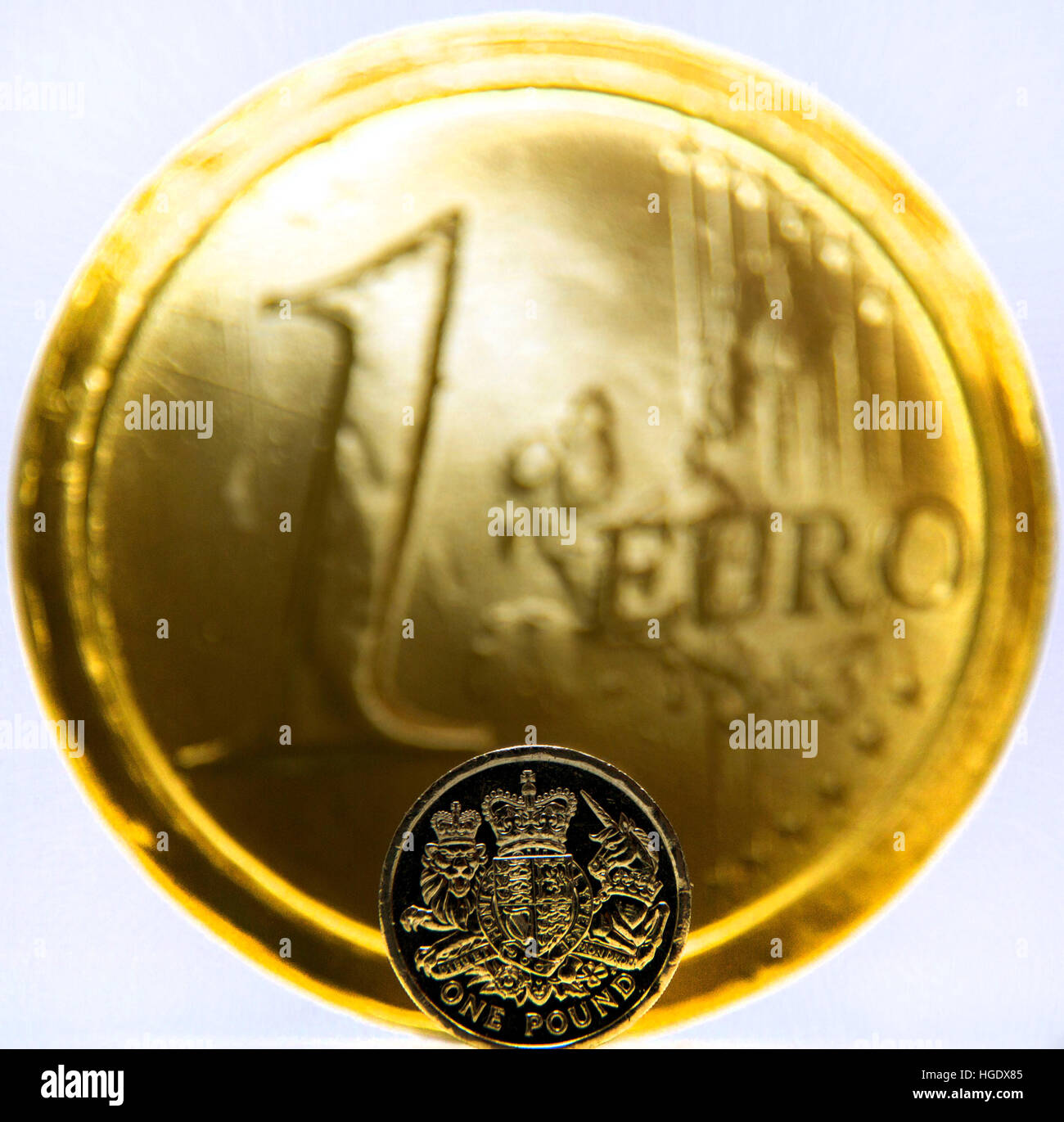 British One Pound coin in front of oversize foil one Euro coin, London ...