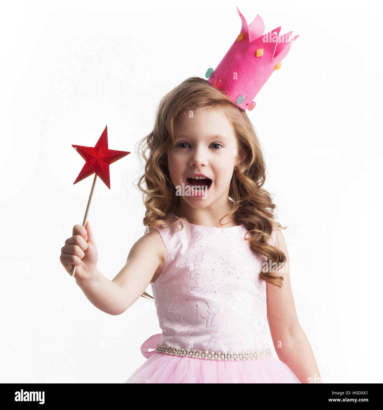 Little fairy girl in pink dress and crown with magic wand putting spell ...