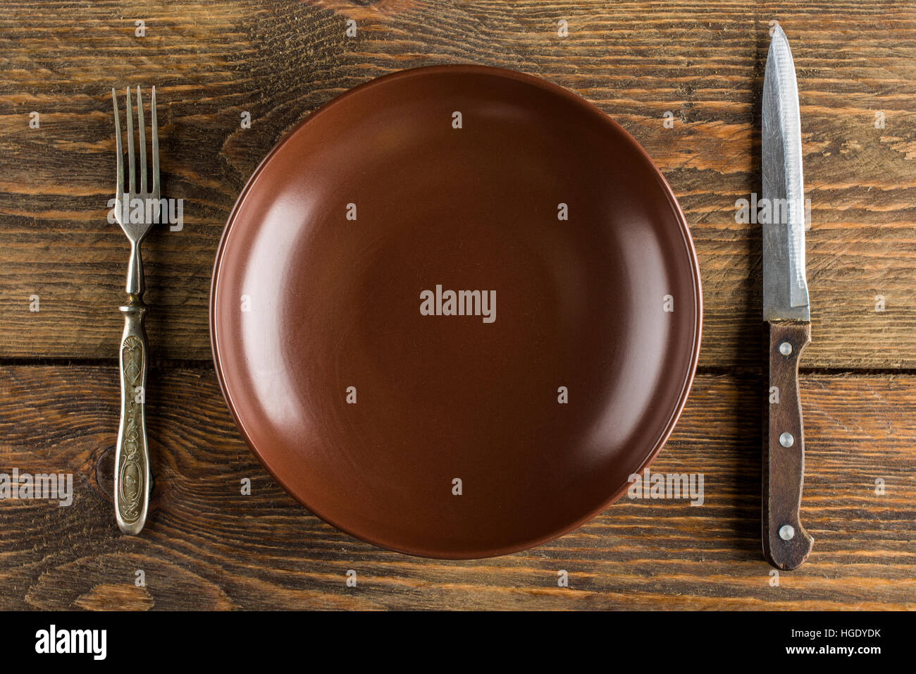 Brown empty dinner plate setting on wooden table Stock Photo - Alamy