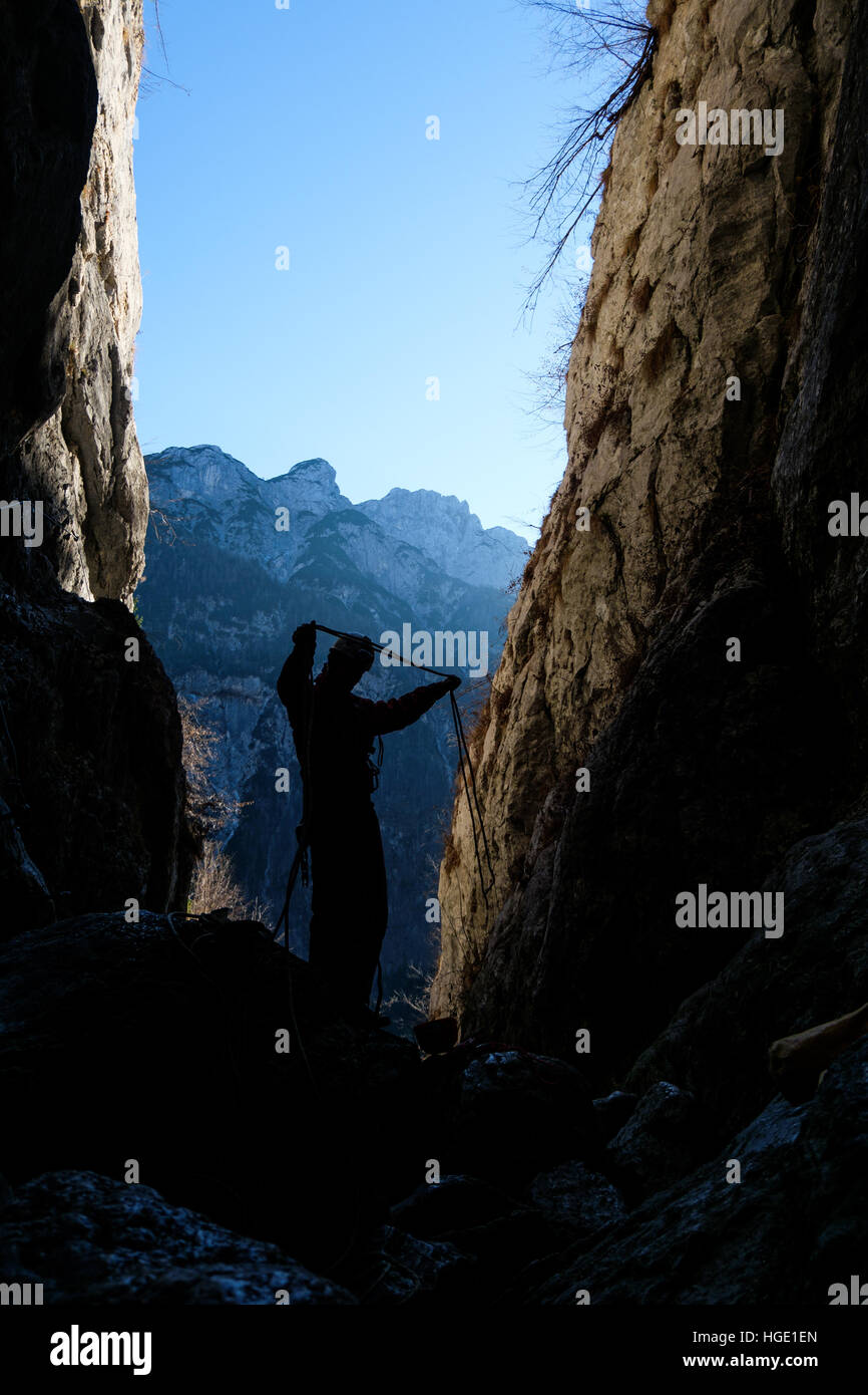 Silhouette of a climber coiling a rope in a narrow gully/canyon Stock ...