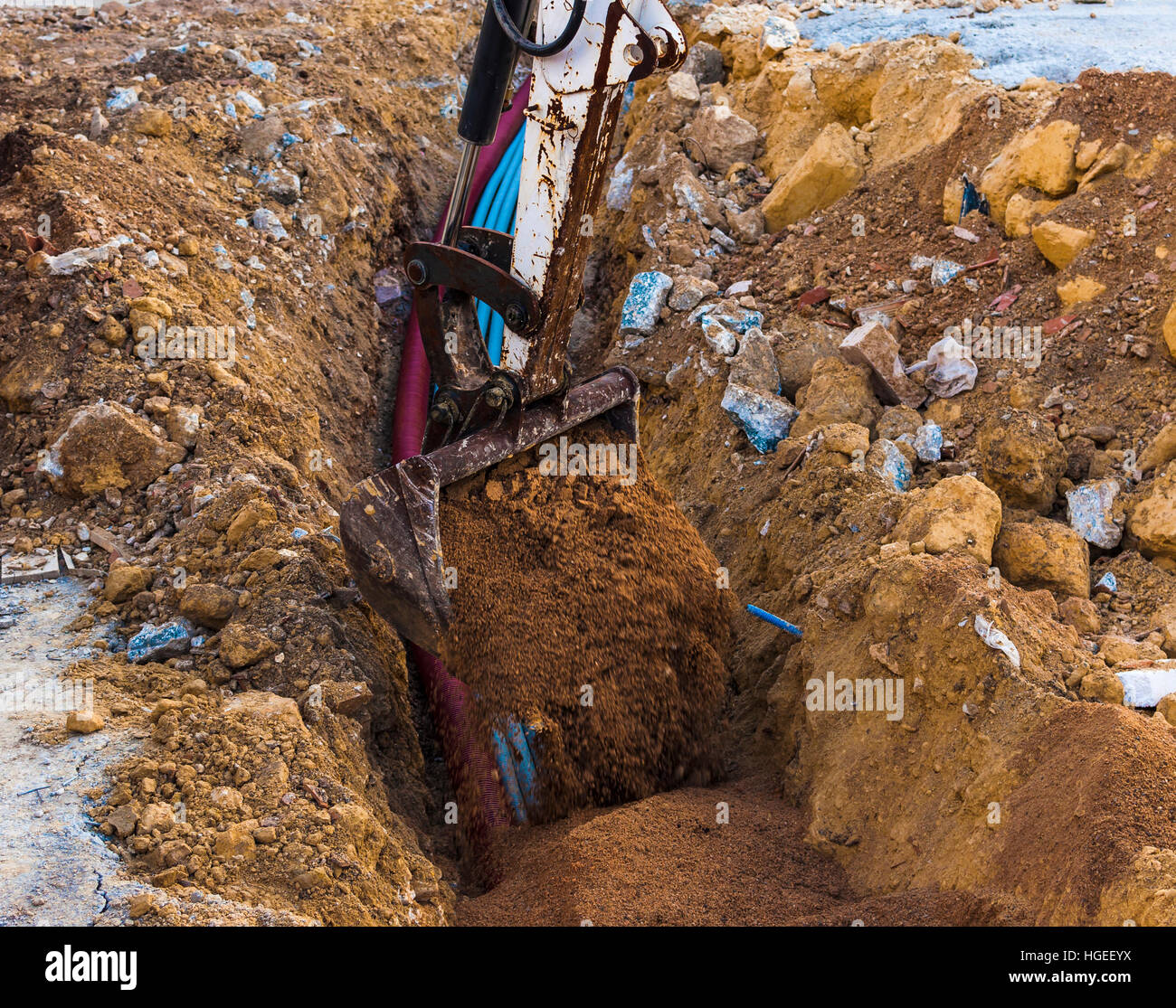 Excavator electrical conduits covered with sand with the assistance of ...
