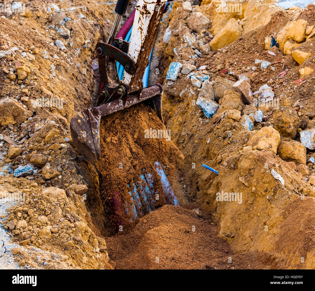 Excavator electrical conduits covered with sand with the assistance of ...