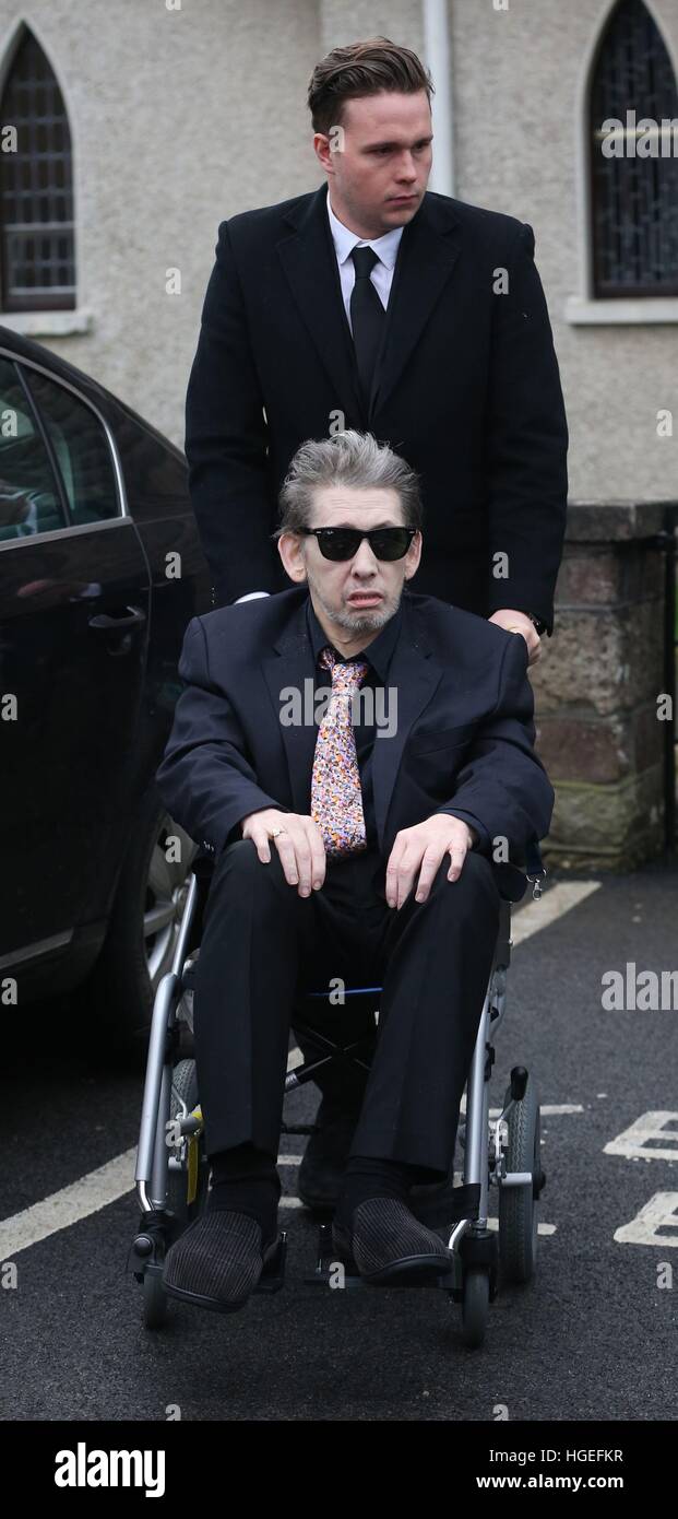 Singer Shane MacGowan is helped from the church as the funeral of his ...