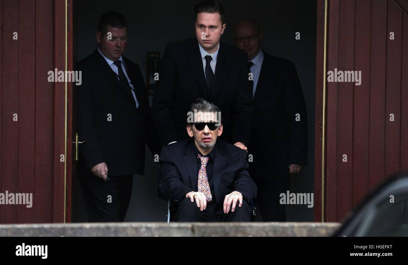 Singer Shane MacGowan is helped from the church as the funeral of his ...