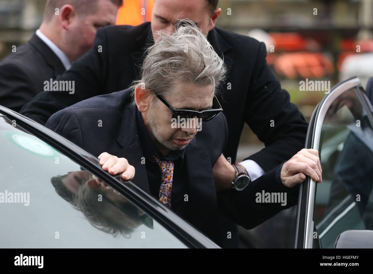 Singer Shane MacGowan is helped from the church as the funeral of his ...