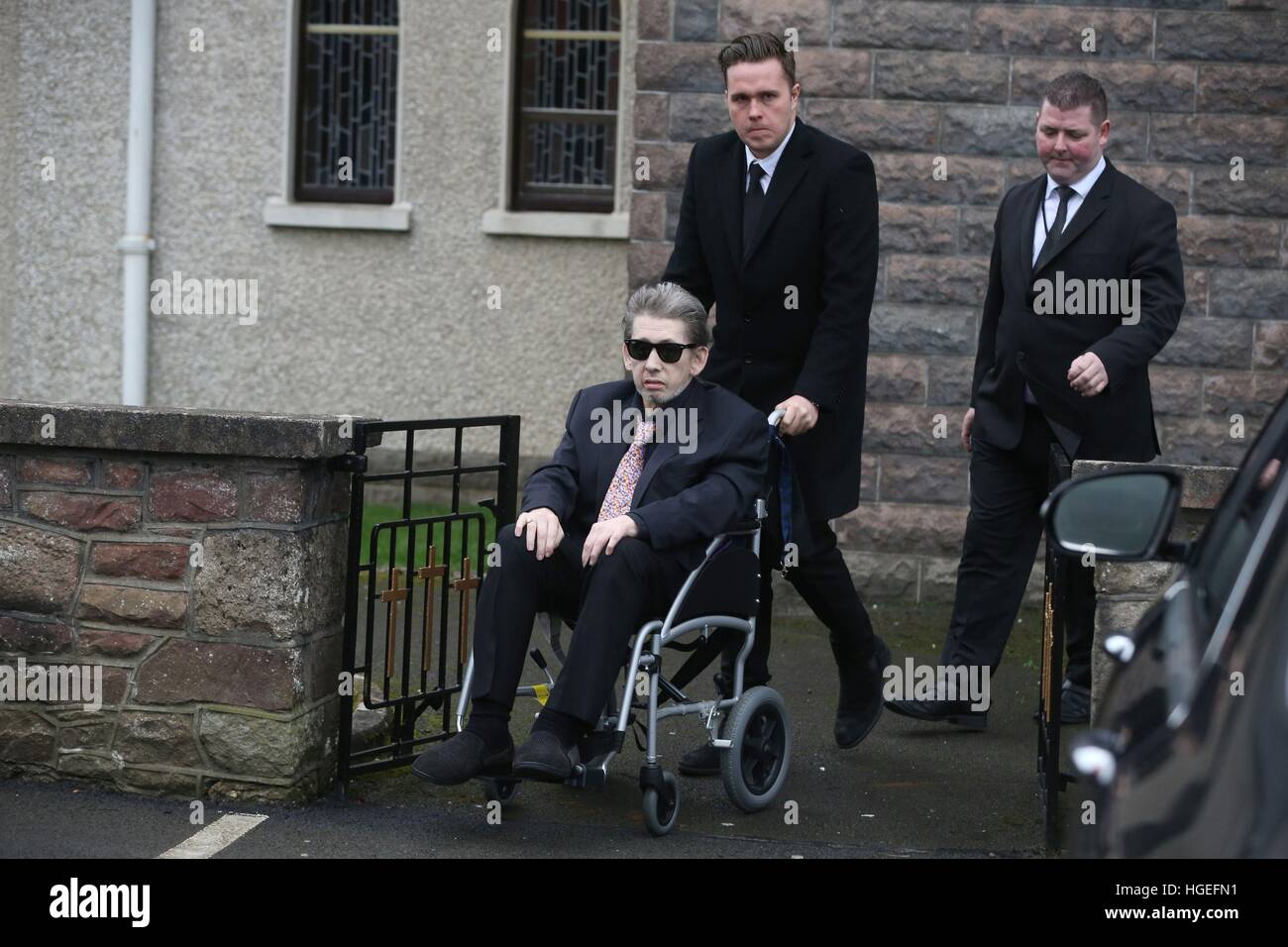 Singer Shane MacGowan is helped from the church as the funeral of his ...