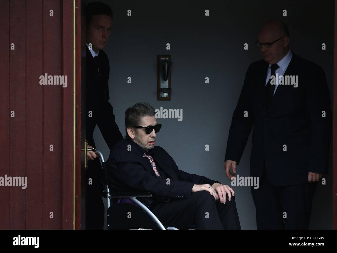 Singer Shane MacGowan is helped from the church as the funeral of his ...