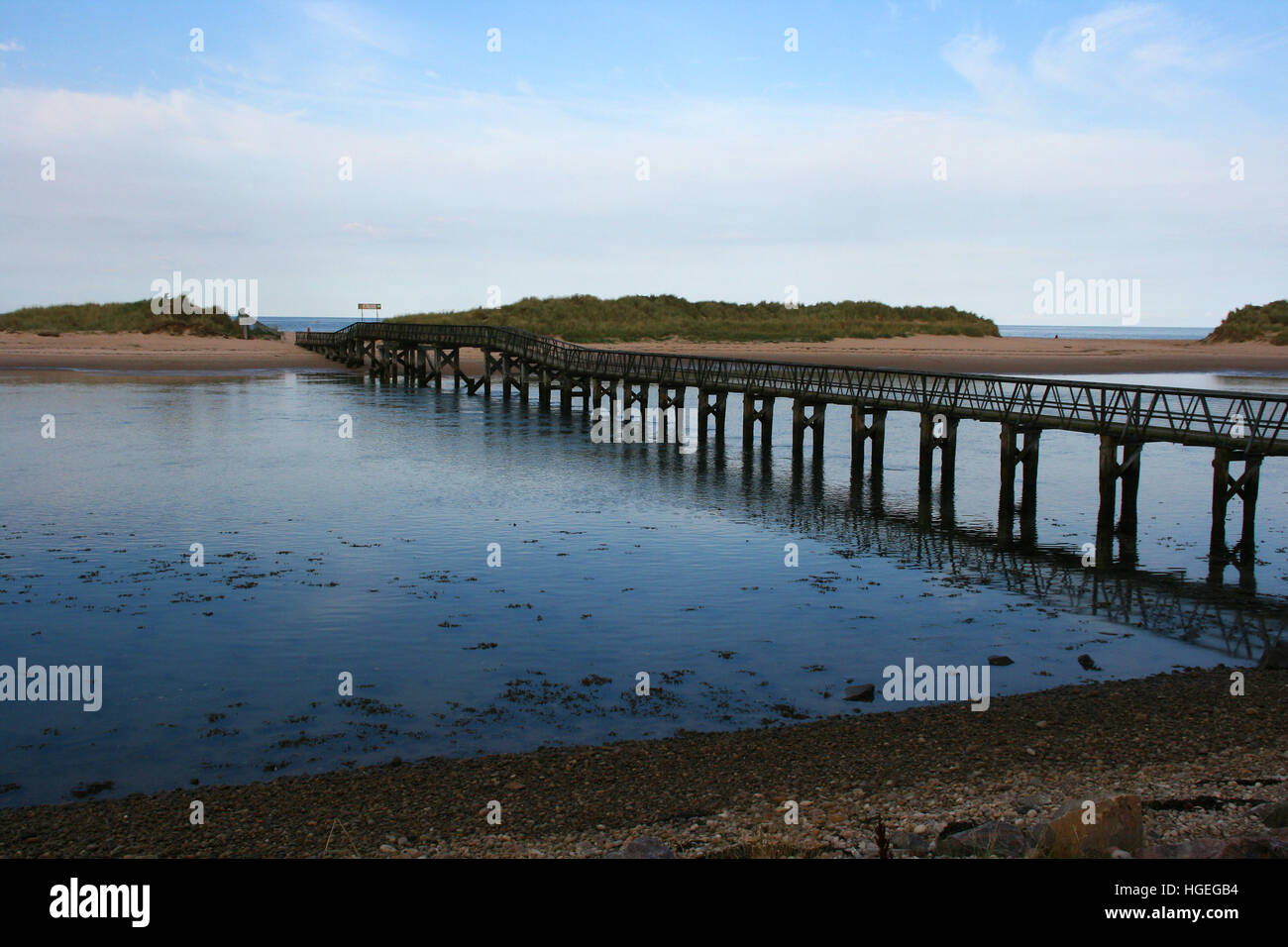 Wooden footbridge over a small sea water inlet separating the mainlaind ...