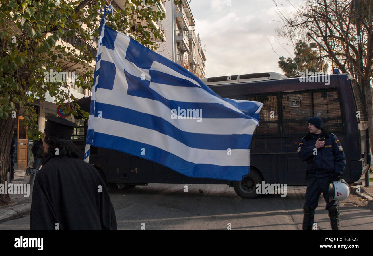 Athens, Greece. 08th Jan, 2017. A Greek priest passes with a Greek flag ...