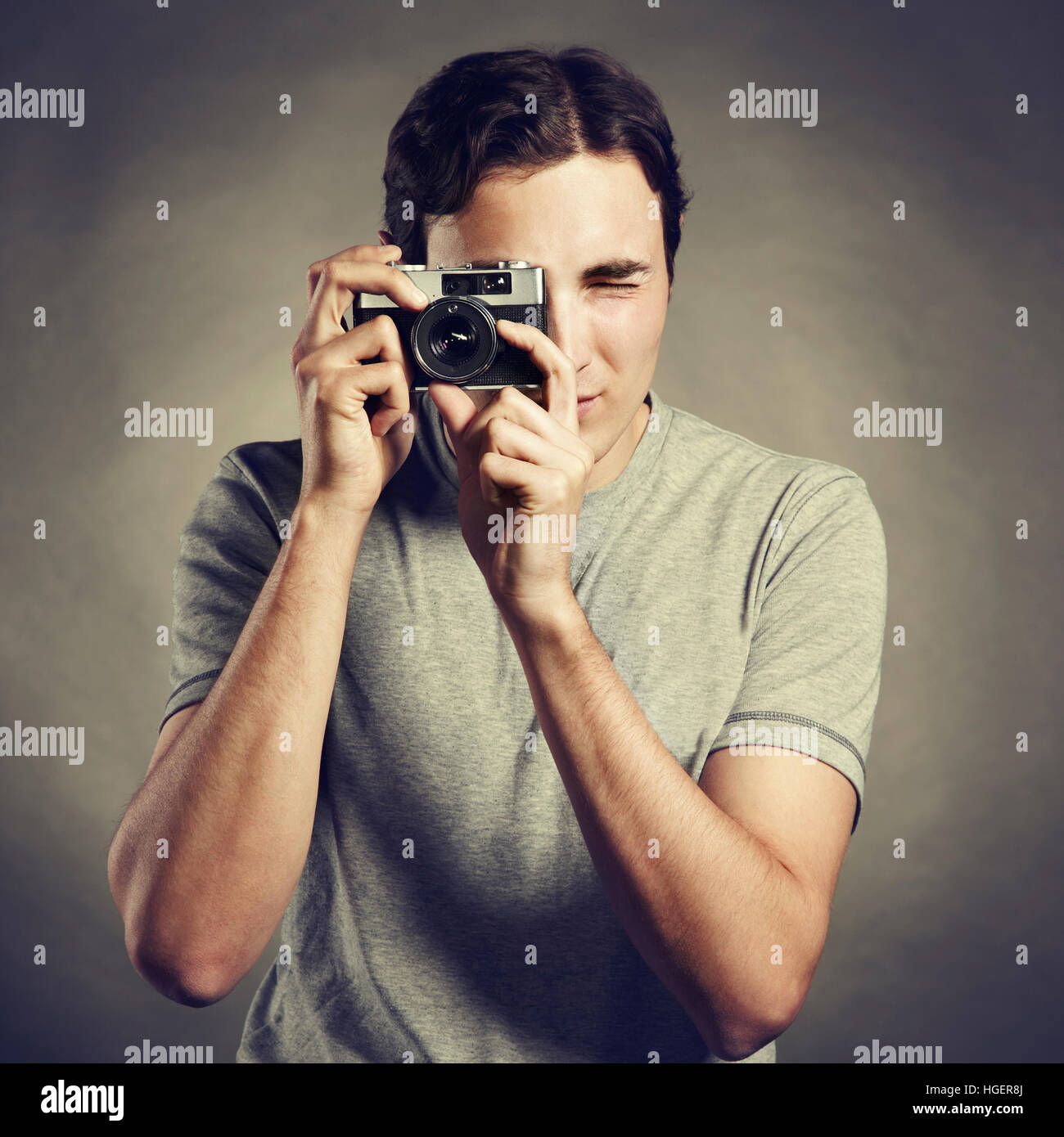 Portrait of young male photographer with a camera. Man shoots at camera ...