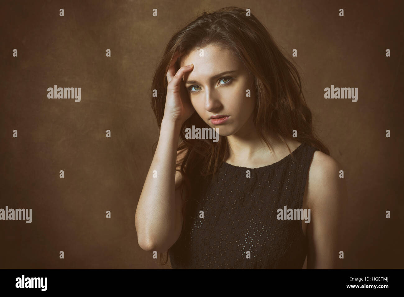 Sad young woman hand touching head Stock Photo - Alamy